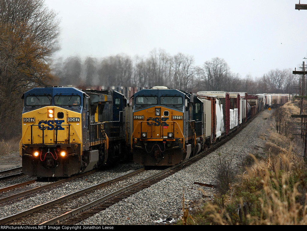 E945 rolls past Q335, which is waiting for a crew